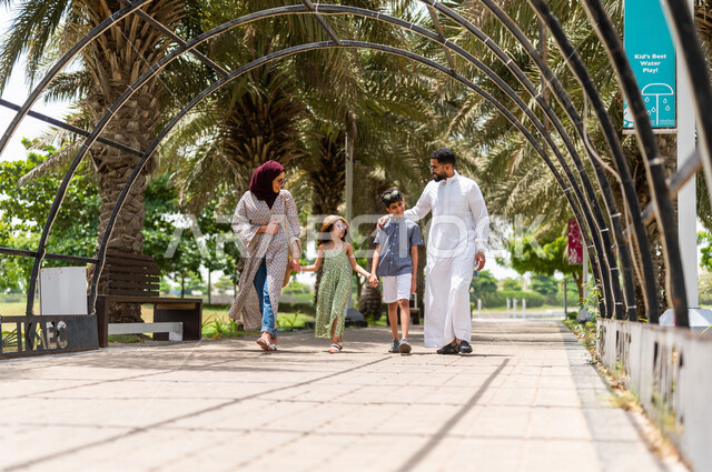 A Saudi Arabian Gulf family walking on the walking path designated for ...