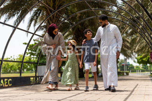 A Saudi Arabian Gulf family walking on the walking path designated for ...