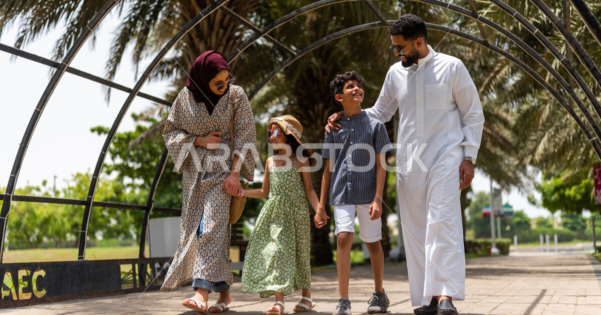A Saudi Arabian Gulf family walking on the walking path designated for ...