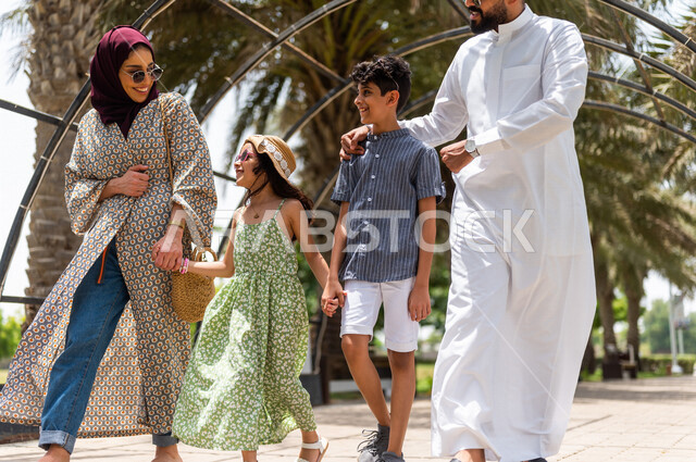 A Saudi Arabian Gulf family walking on the walking path designated for ...