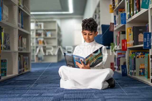 A Saudi Arabian Gulf student reading a book from the school library ...