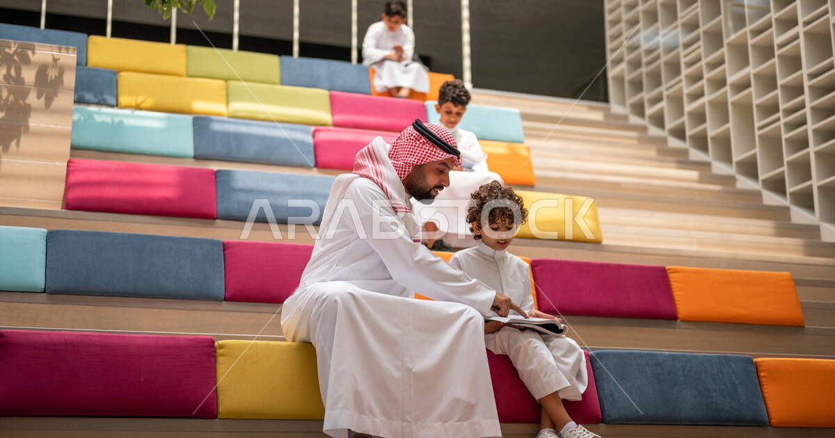 A Saudi Arabian Gulf professor with a group of students sitting on the ...