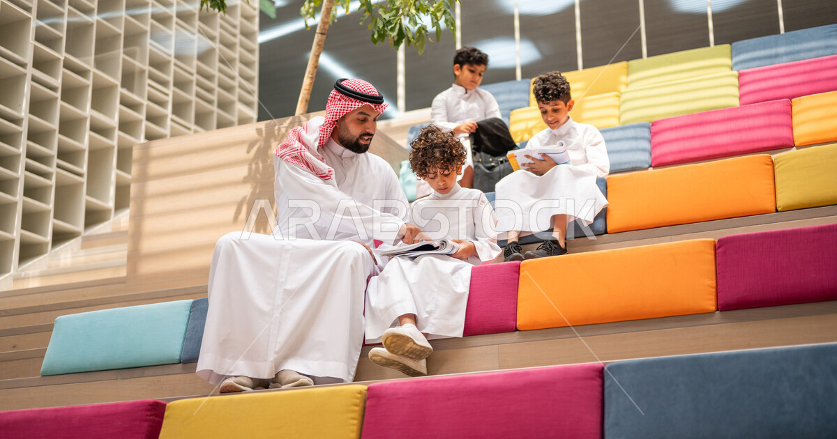 A Saudi Arabian Gulf professor with a group of students sitting on the ...