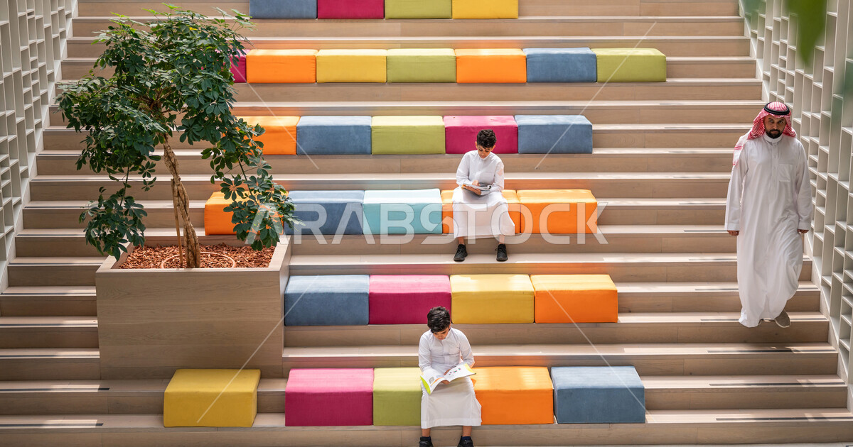 Two Saudi Arabian Gulf students sitting on the stairs in the school ...