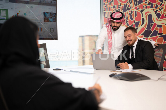 A Saudi team and a man in a formal suit in the meeting room inside the ...