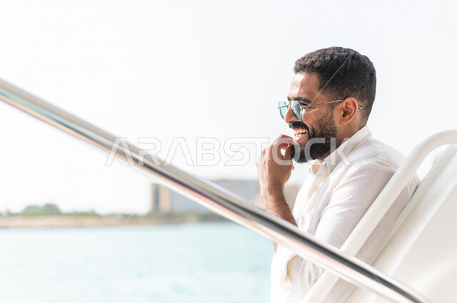 A young Saudi Arabian Gulf man on a yacht in the sea, the pleasure of ...