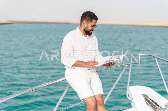 A Saudi Arabian Gulf man on a yacht in the middle of the sea, a hobby ...