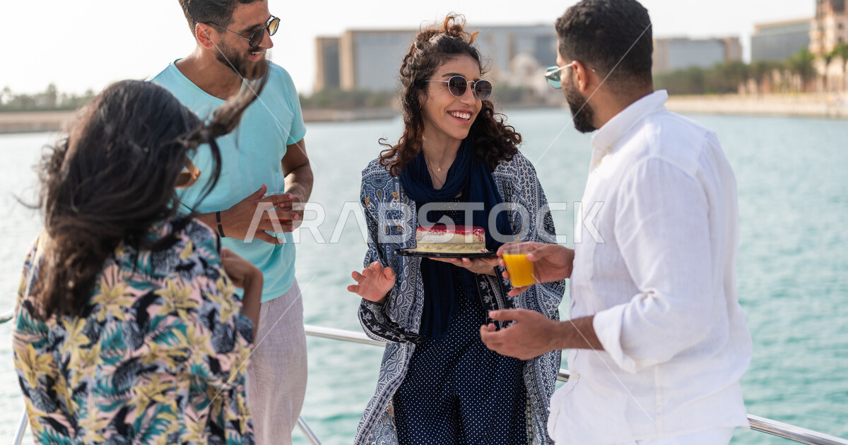A group of Saudi Arabian Gulf friends celebrate on board a yacht ...