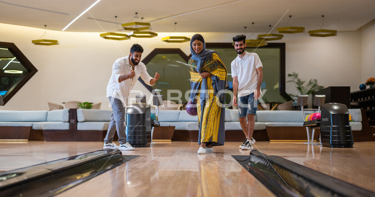 A group of Saudi Arabian Gulf friends practicing bowling, a bowling ...