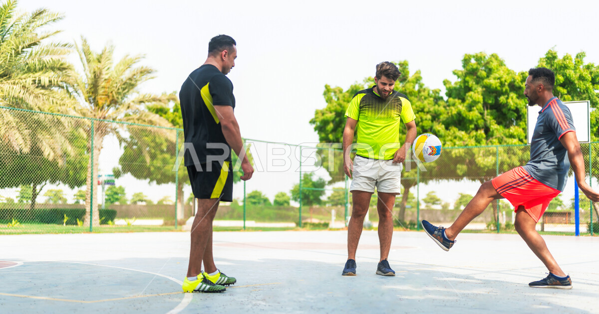 A team of Saudi Arab Gulf friends playing football, playing football in ...