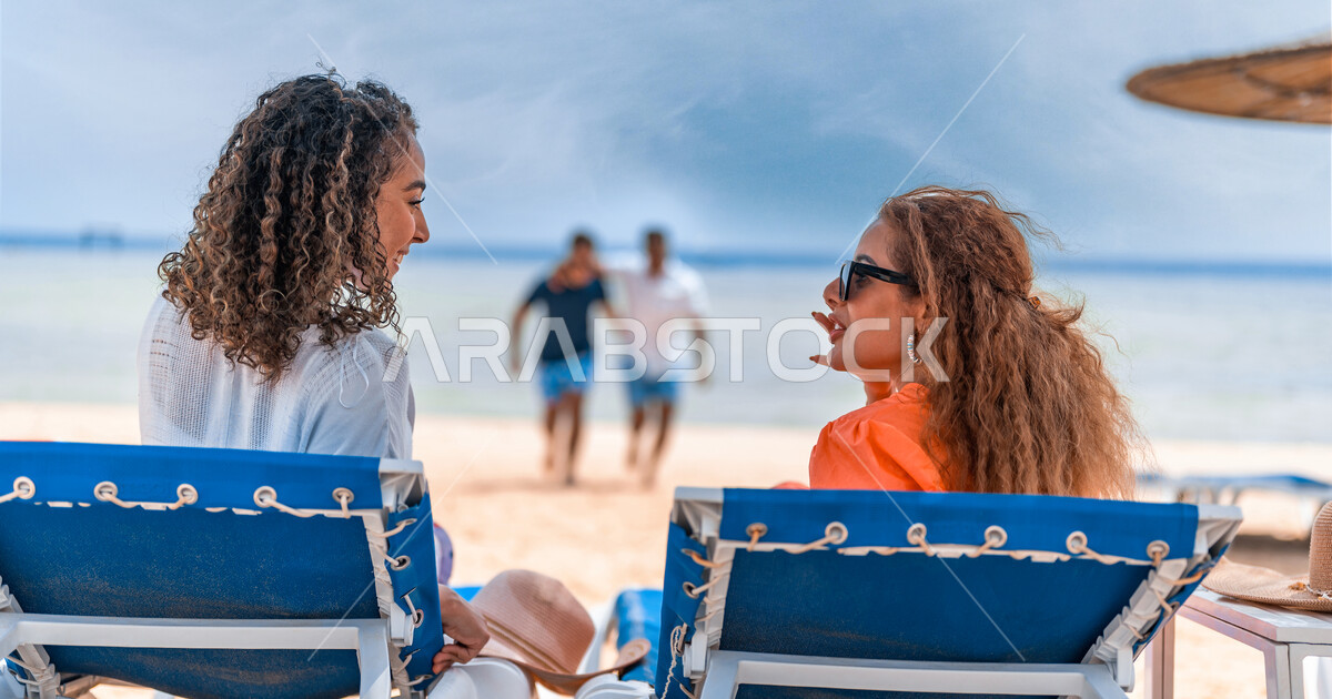 A group of friends meeting on the beach of the Jeddah sea, getting ...