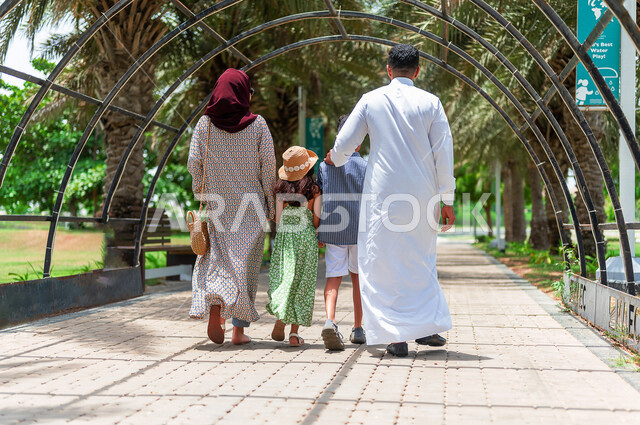 A corner from the back of a Saudi Arabian Gulf family walking on the ...
