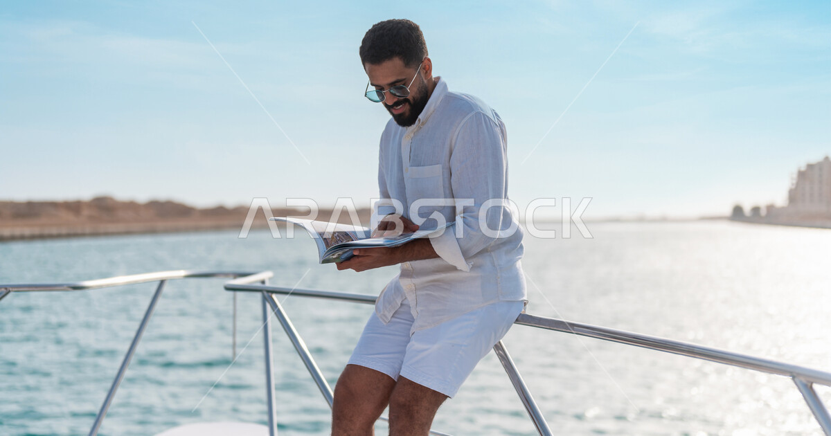 A Saudi Arabian Gulf man on a yacht in the middle of the sea, a hobby ...
