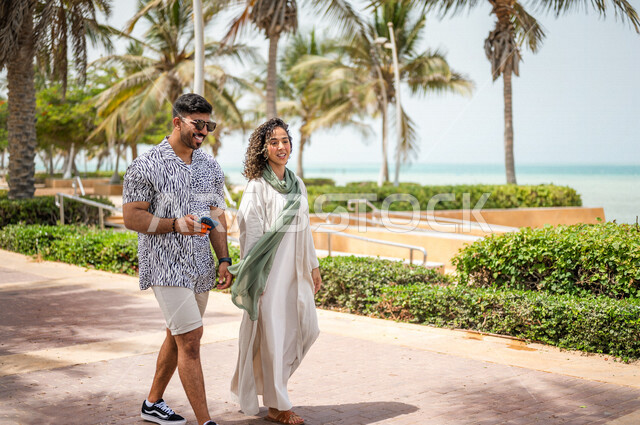 A Saudi Arabian Gulf man and woman walking in Jeddah Corniche promenade ...