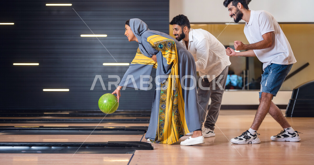Two Gulf Arab Saudi men and women playing bowling, bowling track ...
