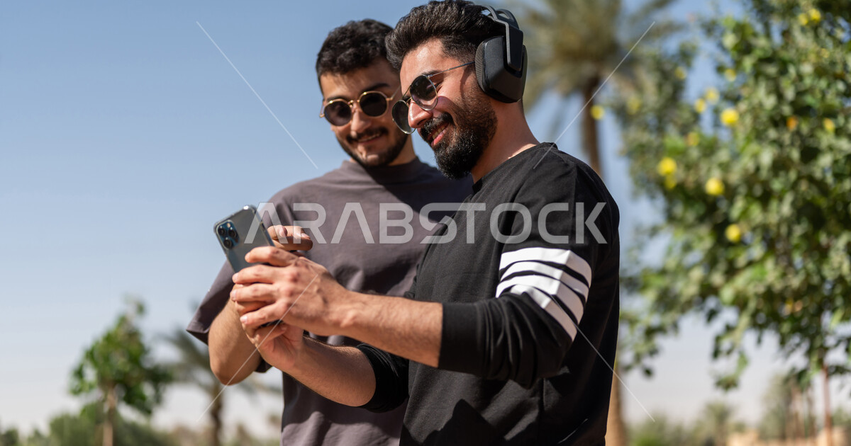 A close-up of two Saudi Arabian Gulf youths wearing sunglasses and ...