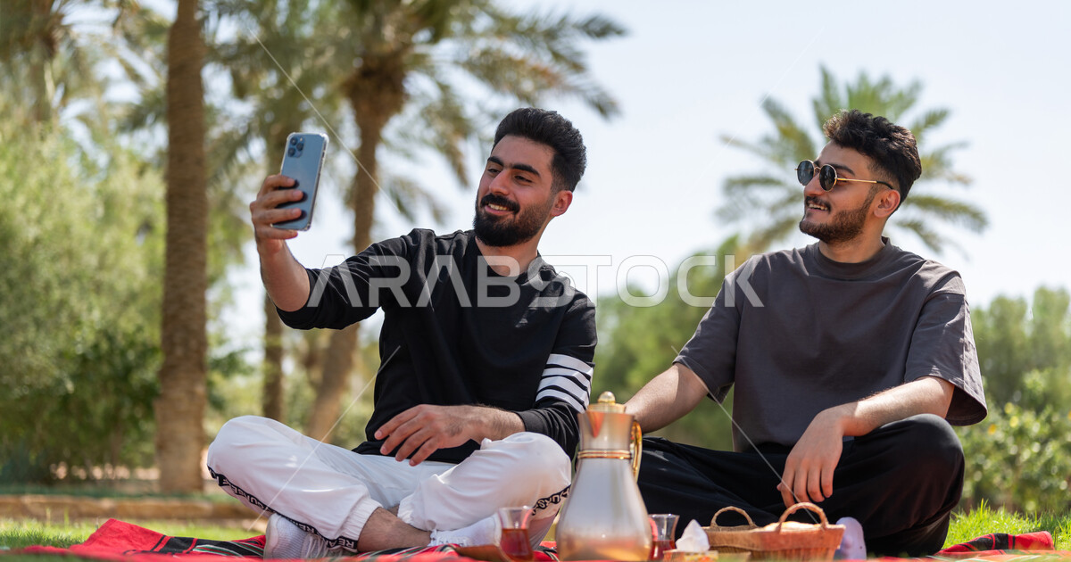 A close-up of two Saudi Arabian Gulf friends enjoying the morning ...