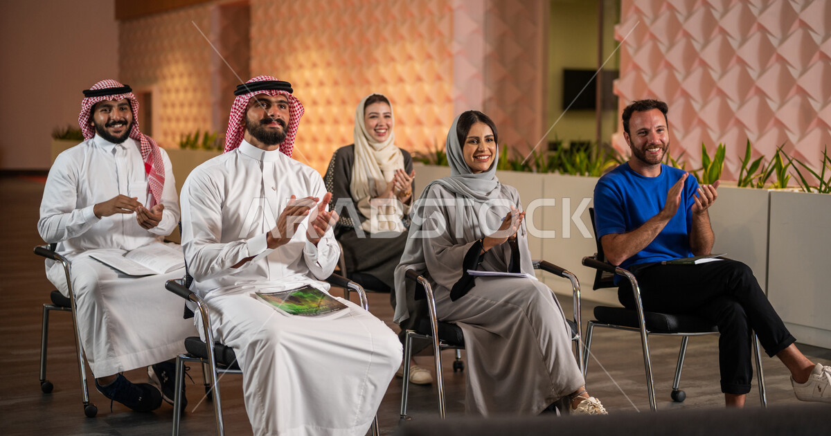 A group of Saudi Arabian Gulf employees in a company’s conference room ...