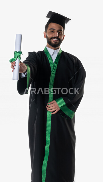 Portrait of a Saudi Arabian Gulf student wearing a gown and graduation ...