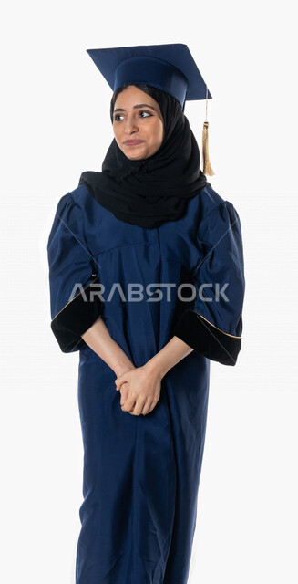 Portrait of a Saudi Arabian Gulf student wearing an abaya and graduation cap, face and hands ...
