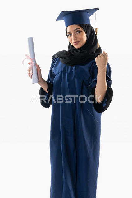 Portrait of a Saudi Arabian Gulf student wearing an abaya and graduation cap, holding a ...