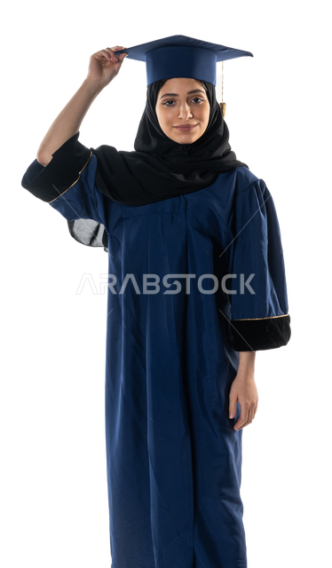 Portrait of a Saudi Arabian Gulf student wearing an abaya and graduation cap, holding a ...