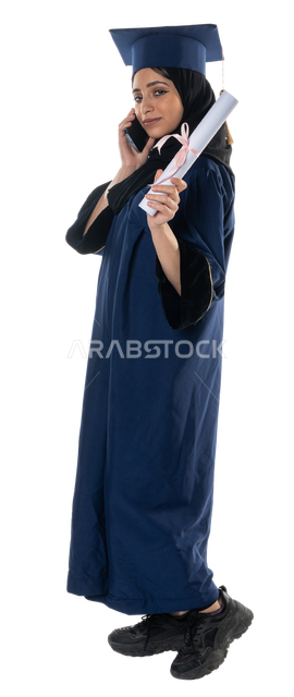 Portrait of a Saudi Arabian Gulf student wearing an abaya and graduation cap, holding a ...