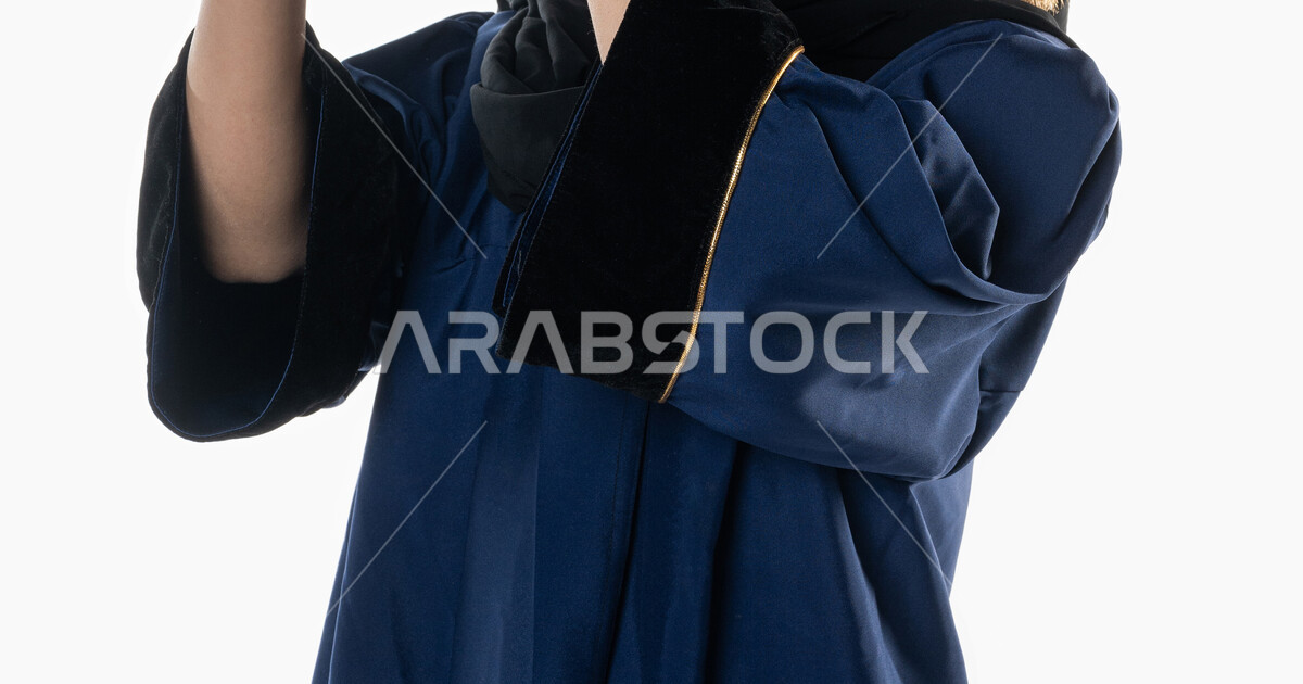 Portrait of a Saudi Arabian Gulf student wearing an abaya and graduation cap, holding a ...