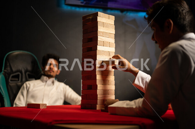Two young Saudi Arabian Gulf teenagers playing Jinga in a cafe in Saudi ...