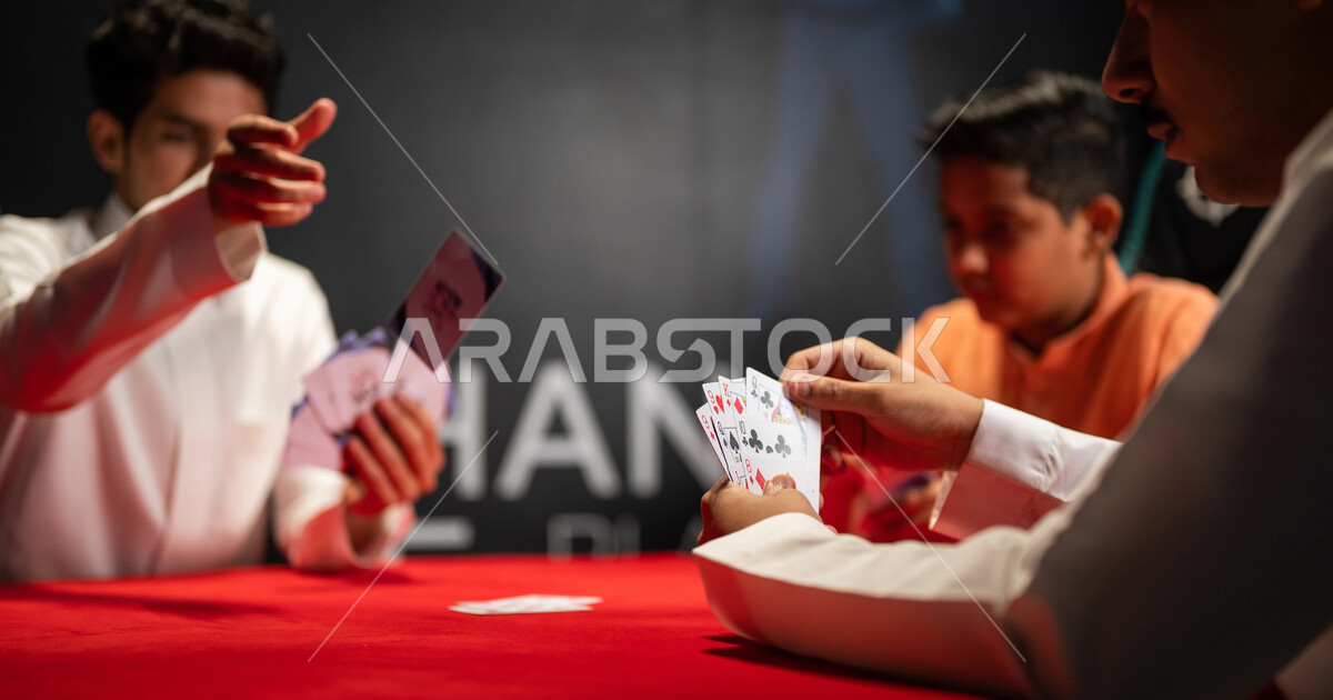 Close-up of a group of Saudi Arab friends playing cards in the cafe ...