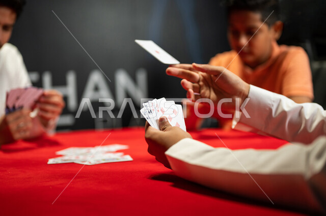 Close-up of a group of Saudi Arab friends playing cards in the cafe ...