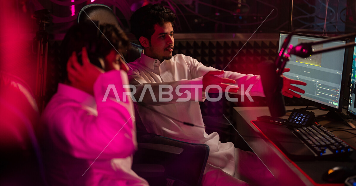 Two young Saudi Arabian Gulf teenagers in an electronic game store, a ...