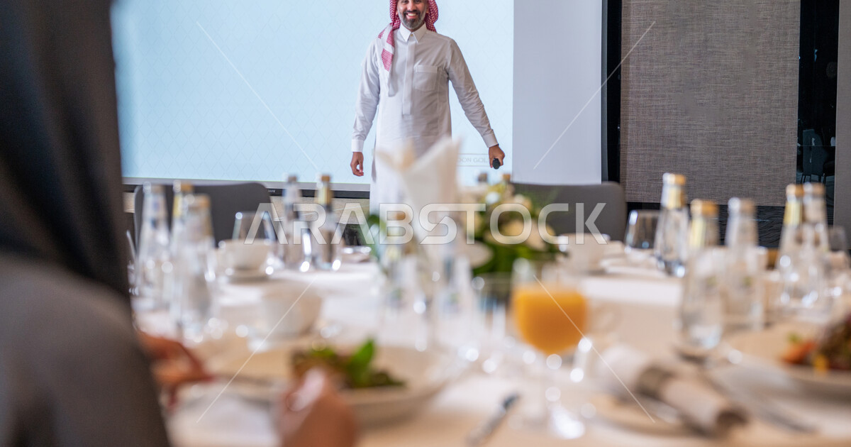 A Saudi Arabian Gulf man giving speeches and an Arab woman sitting at ...