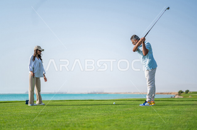A Saudi Arabian Gulf man and woman wearing sports uniforms, challenge ...