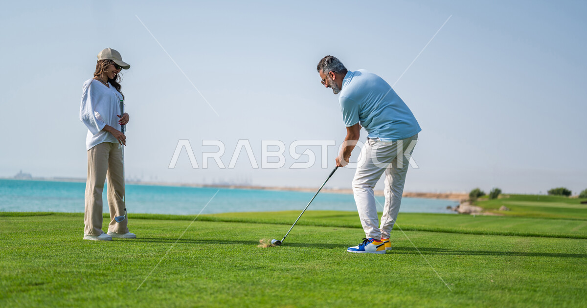 A Saudi Arabian Gulf man and woman wearing sports uniforms, challenge ...