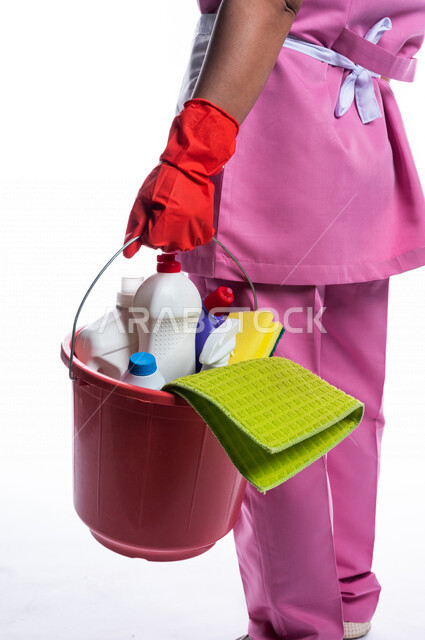 Close-up of a cleaning lady wearing gloves and apron, holding a bucket ...