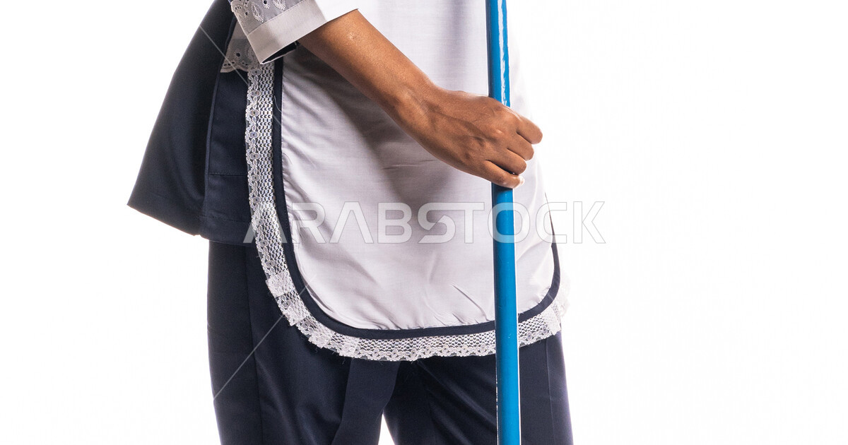 بورتريه لعاملة نظافة ترتدي المئزر، تحمل بيدها المكنسة اليدوية، المهام