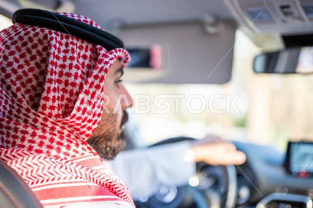 Close-up of a Saudi Arabian Gulf man driving the car, passenger ...