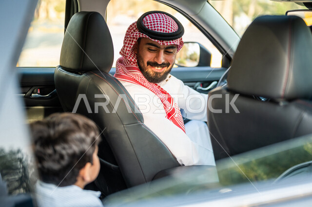 Close-up of a Saudi Arabian Gulf man driving, family enjoying a ride in ...