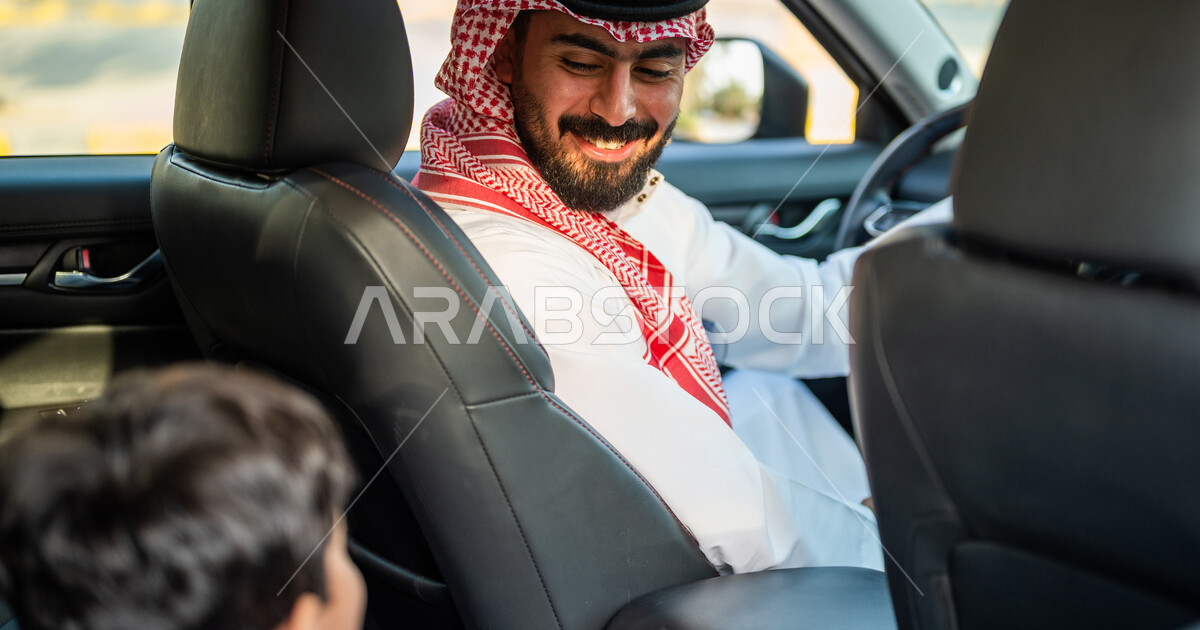 Close-up of a Saudi Arabian Gulf man driving, family enjoying a ride in ...