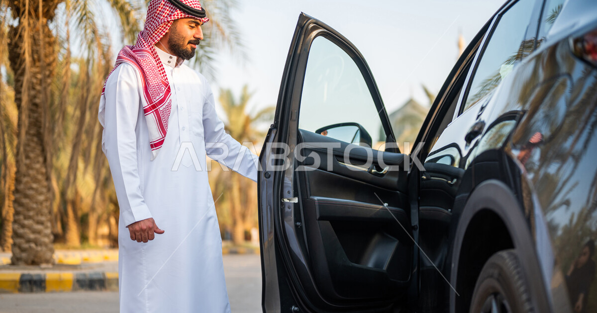 A Saudi Arabian Gulf man opens the car door, prepares to board the car ...