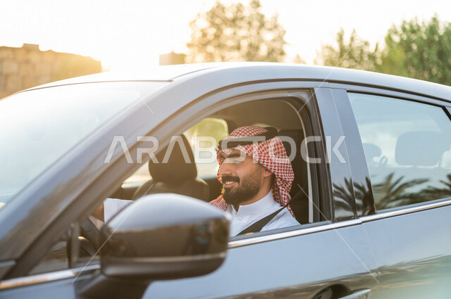A Saudi Arabian Gulf man drives the car and puts the seat belt ...