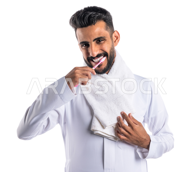 Close-up portrait of a Saudi Arabian Gulf man, brushing his teeth with ...