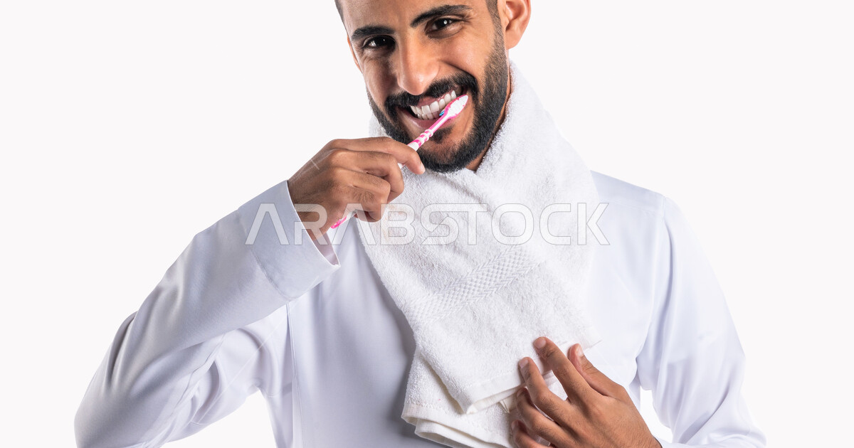 Close-up portrait of a Saudi Arabian Gulf man, brushing his teeth with ...
