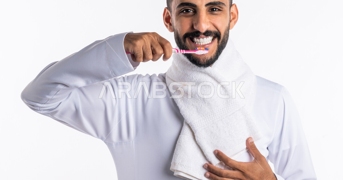 Close-up portrait of a Saudi Arabian Gulf man, brushing his teeth with ...