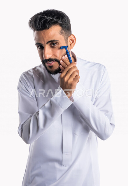 Close-up portrait of a Saudi Arabian Gulf man, removing facial hair ...