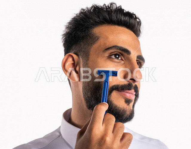 Close-up portrait of a Saudi Arabian Gulf man, removing facial hair ...