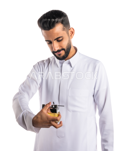 A close-up portrait of a Saudi Arabian Gulf man, applying perfume ...