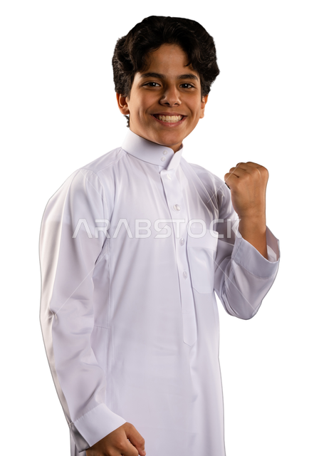Portrait of a Saudi Arabian Gulf boy wearing a Saudi dress raising his ...