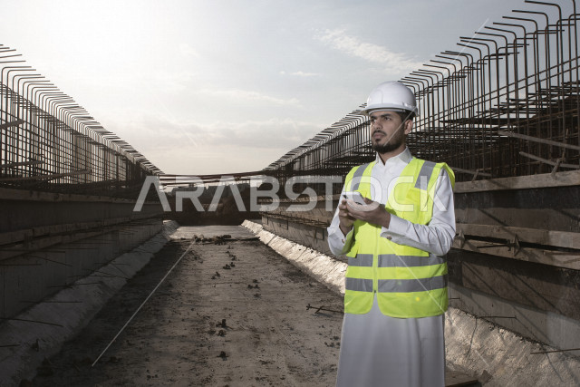 A Saudi Arabian Gulf Arab consultant wears a protective jacket and ...